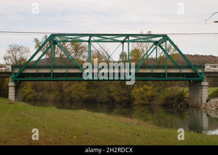 Green painted steel bridge over the Thames at Bourne end with a train ...