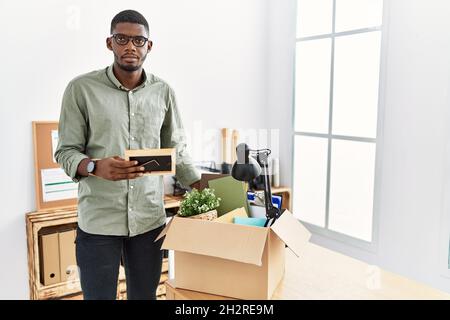Young african american businessman unboxing box at the office pointing ...
