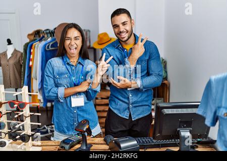 Young interracial people working at retail boutique smiling looking to ...
