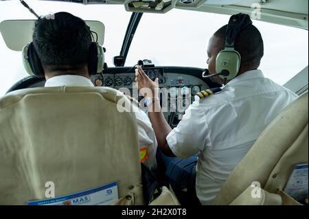 Captain and co-pilot in cockpit getting ready for takeoff in a Cessna ...