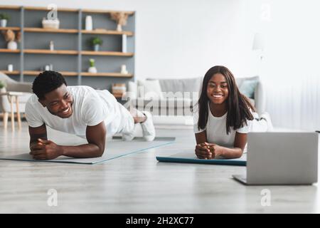 Young black couple planking in front of laptop at home Stock Photo - Alamy