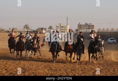 Gaza. 24th Oct, 2021. Palestinian jockeys ride horses as they take part ...