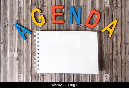 Of multicolored letters, the word AGENDA on a wooden table next to a ...