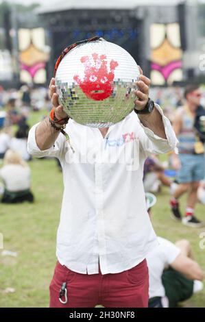 Festival goer holding a Wilson glitter ball on day 2 of Bestival 2014 ...
