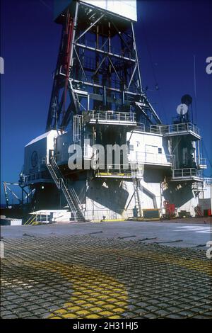 Oil well drilling for oil in Ireland. A farmhouse on the roadside has a ...