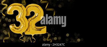 number thirty two, gold foil balloon number on blue velvet background ...