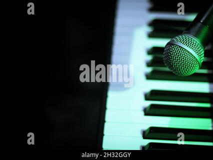 Microphone over piano keys in dim light. No people Stock Photo - Alamy