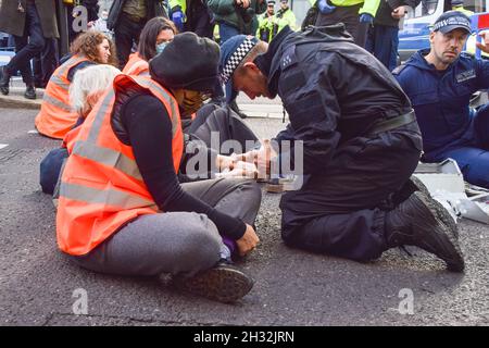Police officers dissolve the glue on a protester's feet during the ...