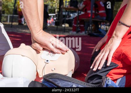 Hands of a paramedic doing chest compression during defibrillator CPR ...