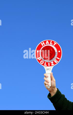 Eine Hand mit einer Polizeikelle, STOP, POLIZEI, Kontrolle ...
