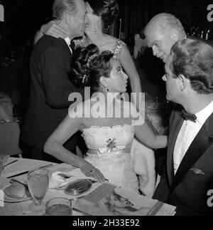 MERLE OBERON and LAURENCE OLIVIER on set candid in the grounds of Denham Studios during a break ...