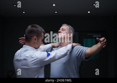 Security guard making body searching procedure with a metal detector on ...