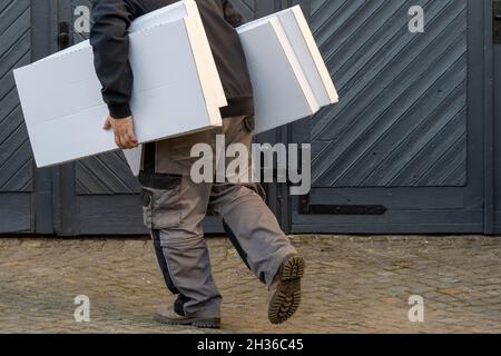 Man running, holding pile of boxes, side view Stock Photo - Alamy