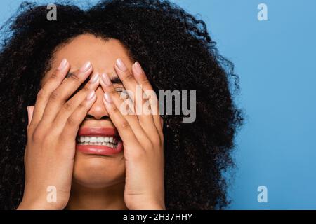 depressed woman obscuring face with hands while sitting at table served ...