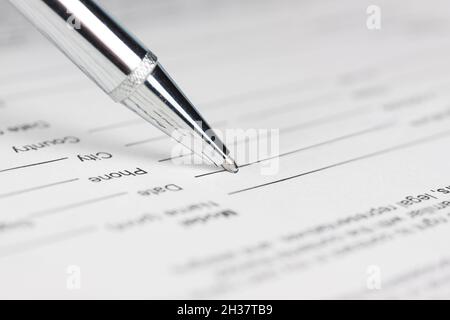 Signing contract pen over form Stock Photo - Alamy