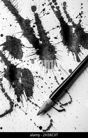Ink spots and brush for calligraphy on white paper Stock Photo - Alamy