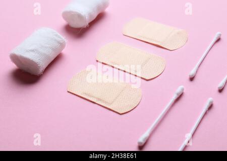 Bandage, medical plasters and cotton buds on color background Stock ...