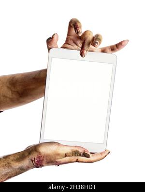 Hands of zombie with tablet computer on dark background. Happy ...