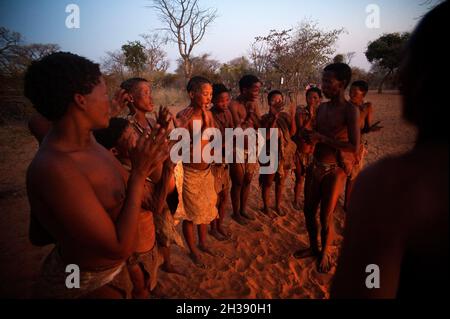 Bushman people around the campfire performing a traditional dance at ...