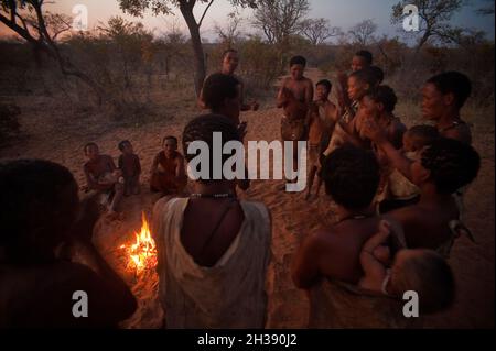 Bushman people around the campfire performing a traditional dance at ...