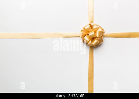 Top view of gold ribbon rolled and yellowbow isolated on colored ...