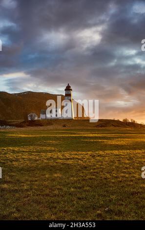 Lighthouse pier and setting sun over the water Stock Photo - Alamy