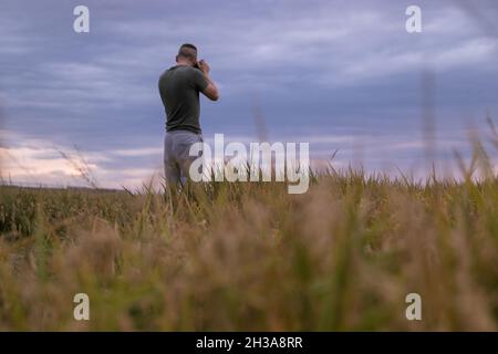 Hispanic man taking pictures of the beautiful grassy field on a cloudy ...