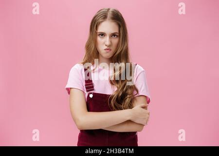 I mad on world. Unhappy hateful young arrogant girl in overalls with ...