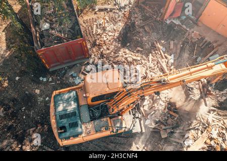Process of demolition building dismantling aerial top view. Excavator ...
