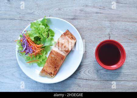 grilled salmon steak dipping teriyaki sauce with fresh vegetable salad on plate Stock Photo - Alamy