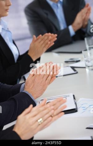 Group of business professionals are seated and clapping ...