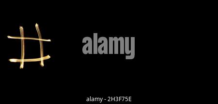 Neon hashtag sign. Light painting yellow hashtag sign against black ...