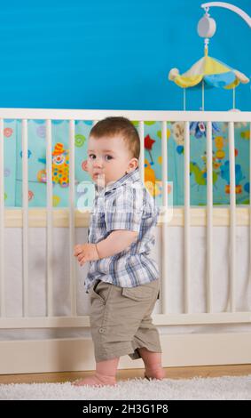 Toddler boy standing on toy scooter Stock Photo - Alamy