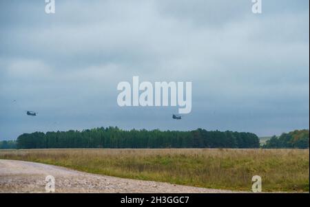 Two blue and white helicopters landing in a grass field Stock Photo - Alamy