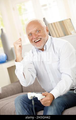 Winning in computer game. Man raises hands with joystick, celebrating ...