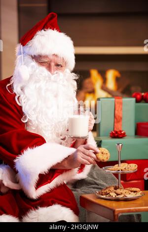 Santa Claus eating cookies and drinking milk on Christmas Eve. Happy ...