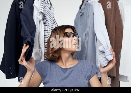 emotional woman selection of clothes near the wardrobe light background ...