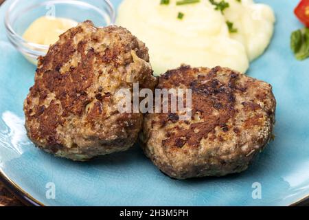 Two meatballs on a plate with mustard and ketchup Stock Photo - Alamy