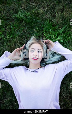 Just chilling. a young woman listening to music while relaxing at home ...