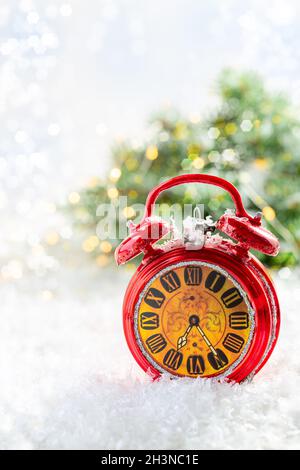 Vintage alarm clock with Christmas decor on red background, closeup ...