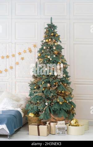 Interior of cozy bedroom with Christmas tree, big bed and glowing ...