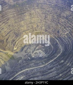 Iron ore opencast mining quarry with lots of machinery at work digging ...