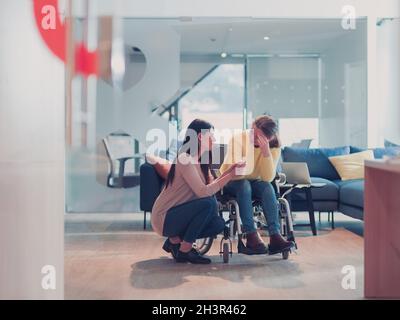 Sad and depressed disabled businesswoman in a wheelchair at the office ...
