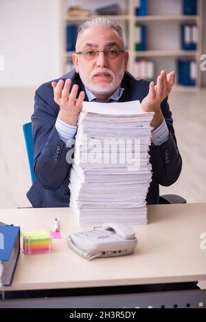 Old employee unhappy with excessive work in the office Stock Photo - Alamy
