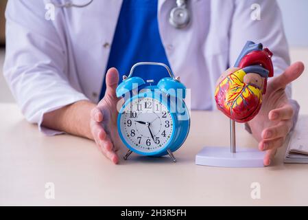 Young doctor cardiologist in time management concept Stock Photo - Alamy