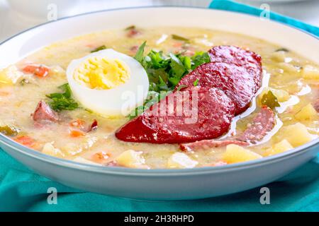 Traditional easter soup white borscht with eggs and daffodils, easter ...