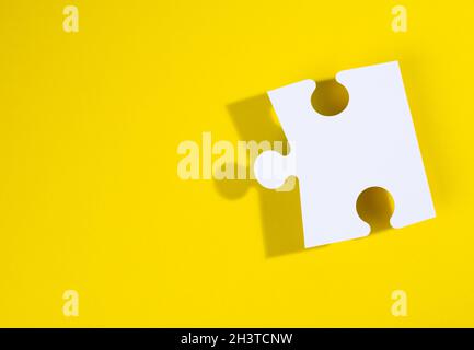 large blank white paper puzzle with shadow on yellow background, top ...