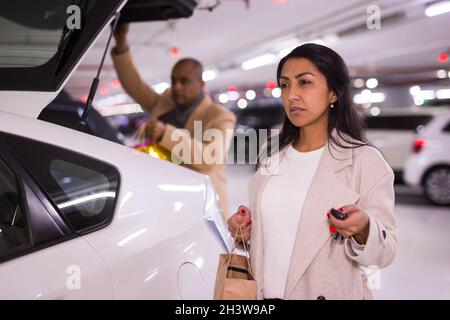 Adult woman with bags in underground parking lot Stock Photo - Alamy