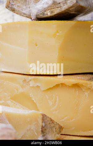 Parmesan is on the table for sale on the market. Parmigiano-Reggiano is ...