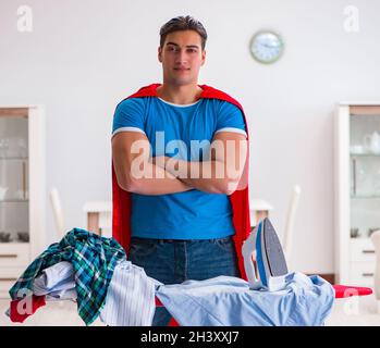 The super hero man husband ironing at home helping his wife Stock Photo ...